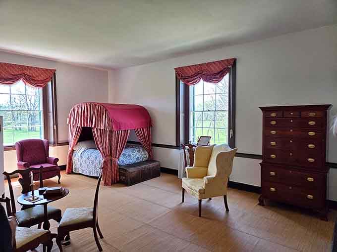 A canopied bed draped in crimson silk reminds you that even early Ohio governors slept in serious style.
