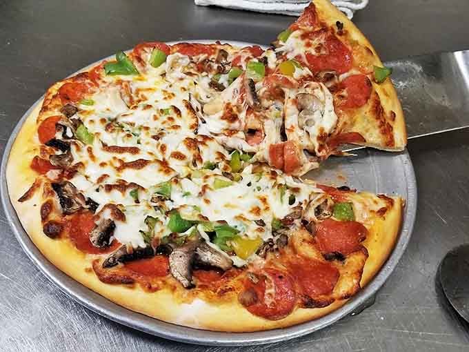 Pepperoni, mushrooms, and green peppers piled high. Someone in that kitchen genuinely cares about every single slice.