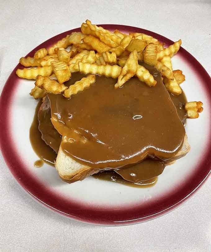 That brown gravy cascading over a meatloaf sandwich with crinkle-cut fries is comfort food doing its absolute finest work.