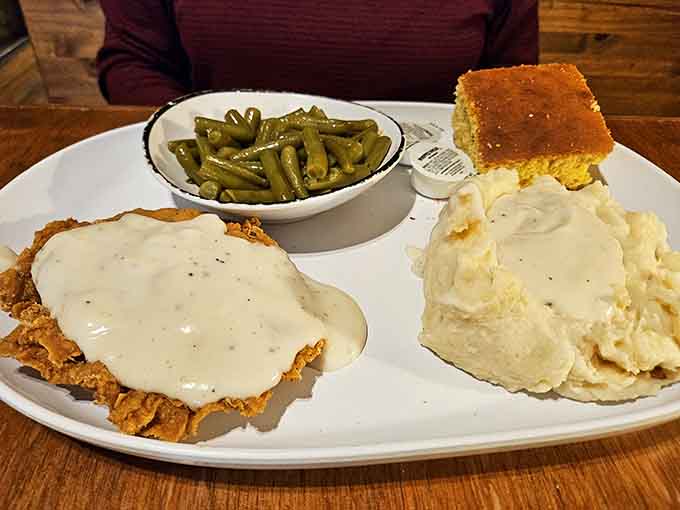 Chicken Fried Chicken smothered in country gravy, with green beans and mashed potatoes alongside. Southern cooking at its most honest and glorious.