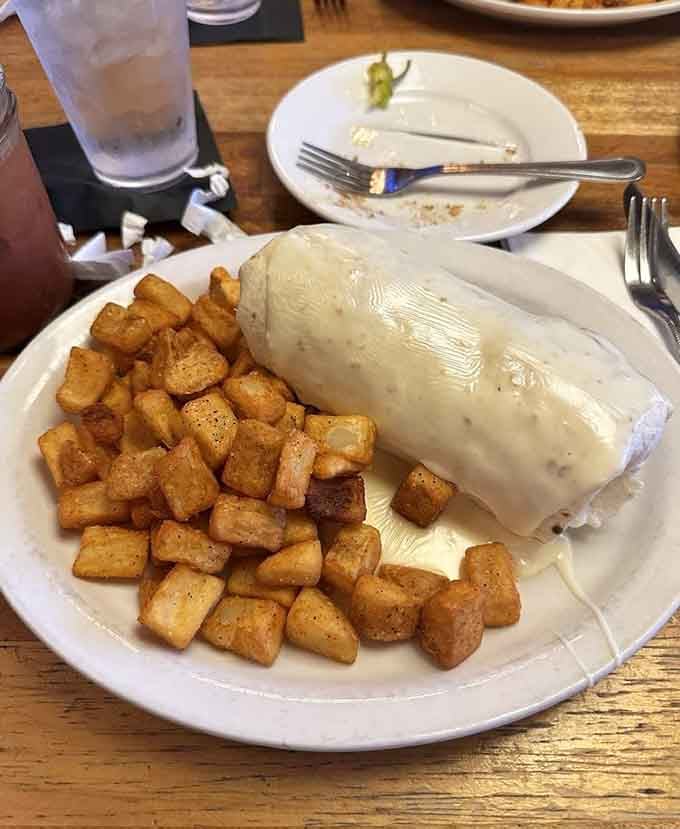 A breakfast burrito smothered in creamy white gravy, served alongside those gorgeous seasoned potatoes, is basically a hug you can eat.
