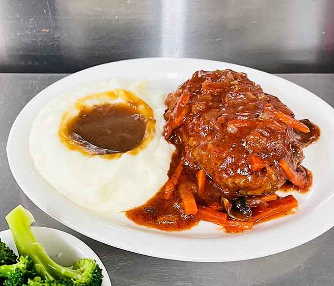 Salisbury steak smothered in rich sauce with mashed potatoes and gravy. Pure, unapologetic comfort on a plate.