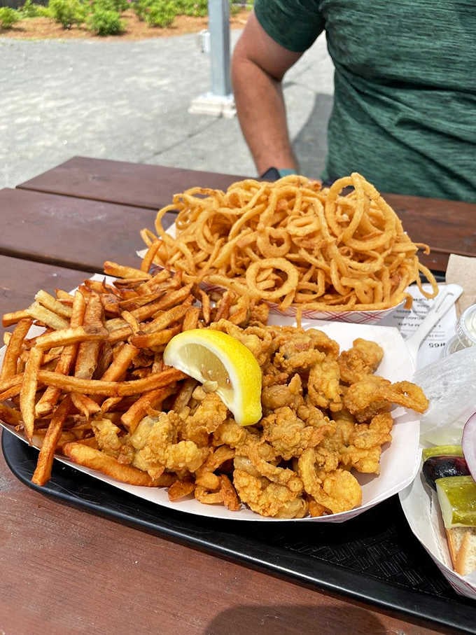 Golden fried clams piled high alongside fries and onion rings: comfort food executed with genuine care.