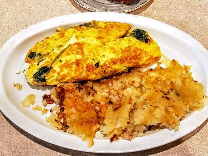 A golden spinach and feta omelet paired with hash browns delivers the kind of satisfying breakfast that fuels your entire day.