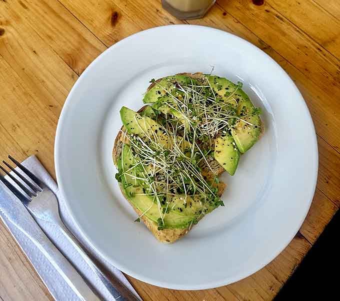 Avocado toast elevated with sprouts and everything seasoning, proving simple ingredients can create something extraordinary when treated right.