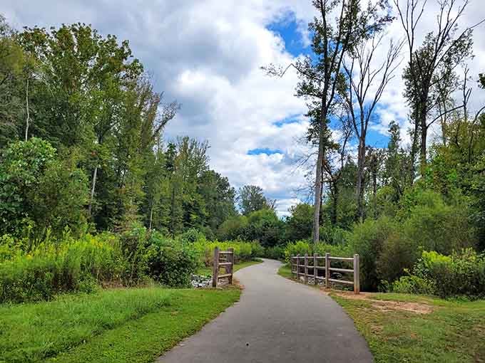 A winding paved path disappearing into lush greenery at Fisher Farm is nature's way of saying, "Put the phone down and walk."