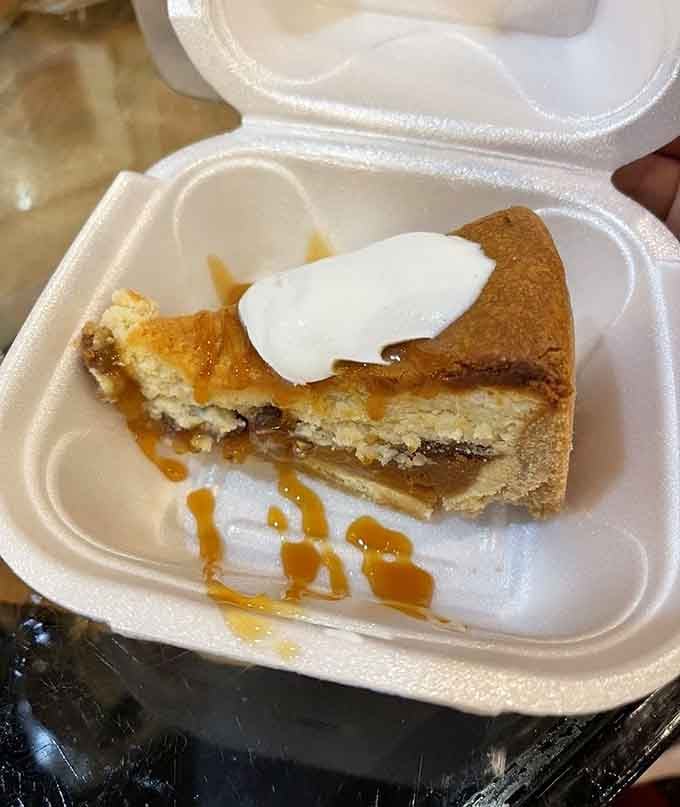 A slice of pecan pie cheesecake drizzled with caramel and topped with whipped cream. Dessert doesn't get more Southern than this.