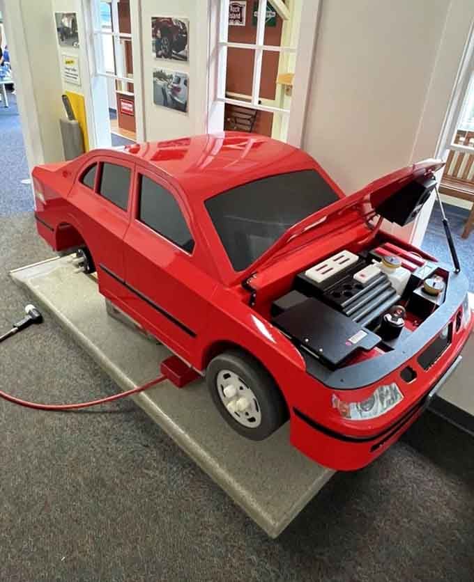That shiny red car with its hood propped open isn't waiting for a mechanic, it's waiting for the next generation of curious minds.