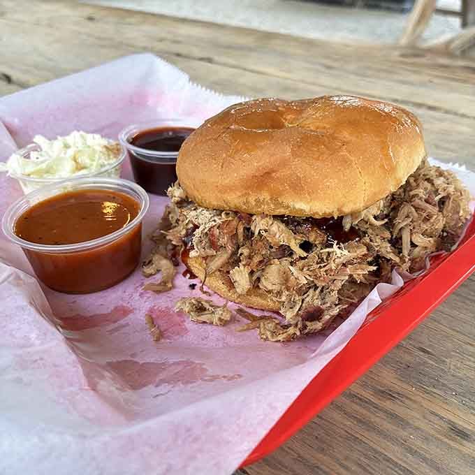 Smoky, tender pulled pork spilling out of a golden bun, with sauce on the side because you're in charge here.