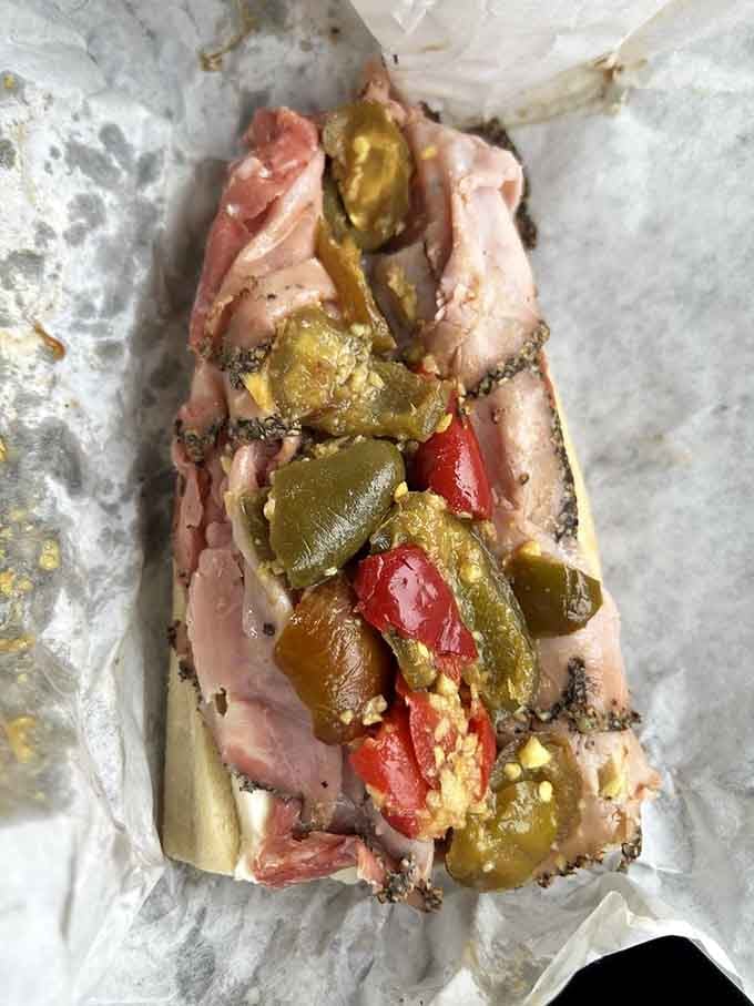 Hot peppers and Italian meats creating the kind of heat that makes you sweat happily through every bite.