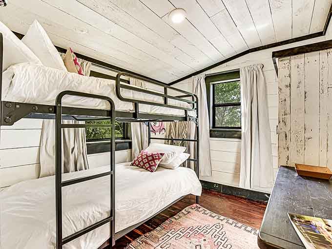 Bunk beds with crisp white linens and rustic wood walls. It's summer camp, but the grown-up version you actually want to attend.