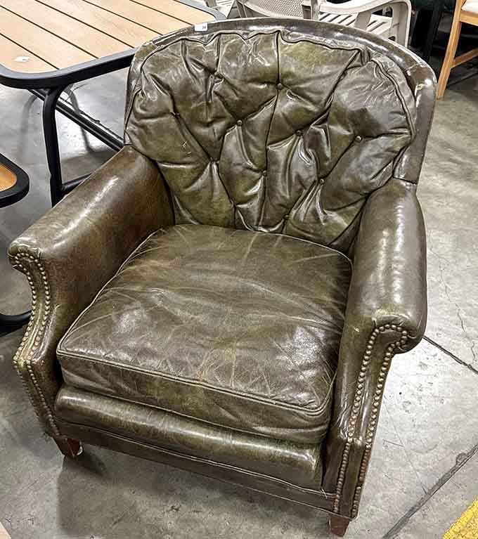 A tufted leather armchair with serious character, just waiting for someone to claim it as their reading throne.