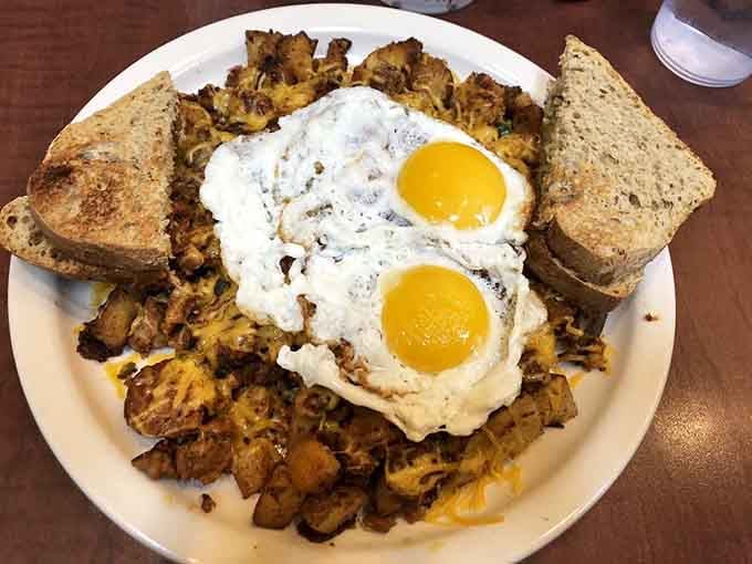 Two perfect sunny side up eggs crowning a hash so good, you'll want to cancel your afternoon plans.