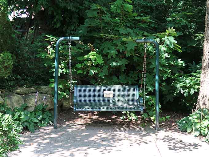 Tucked under a canopy of trees, this little swing bench is basically nature's version of a front porch.
