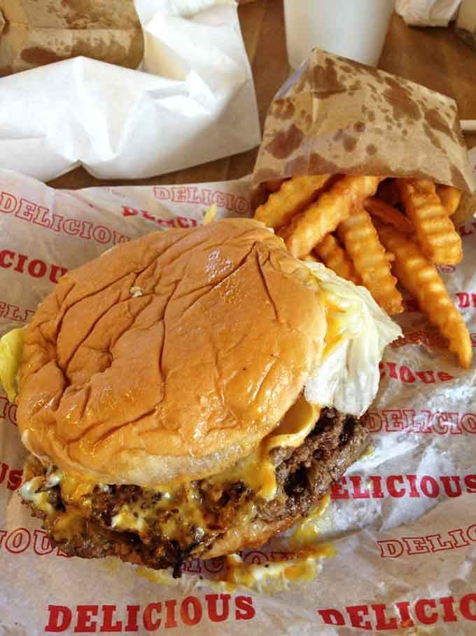 Melted cheese dripping down a double patty with crinkle fries on the side. This is not a drill.