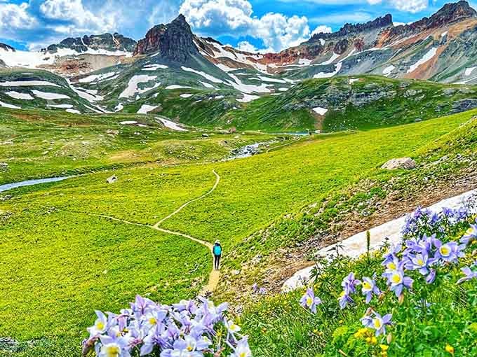 Colorado columbines in full bloom line the path ahead, practically escorting you toward something extraordinary waiting just over the ridge.