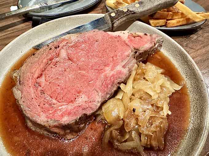 Caramelized onions pooled alongside a perfectly rosy prime rib. This is what a standing ovation looks like on a plate.
