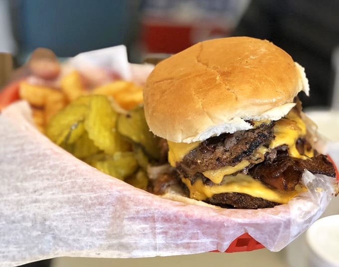 Melted cheese cascading over two patties like a golden waterfall of pure, unapologetic diner perfection.