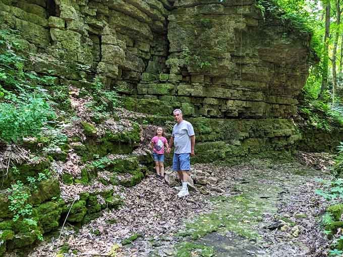 Two generations discovering ancient mossy limestone walls together, proof that the best family memories don't require a screen.