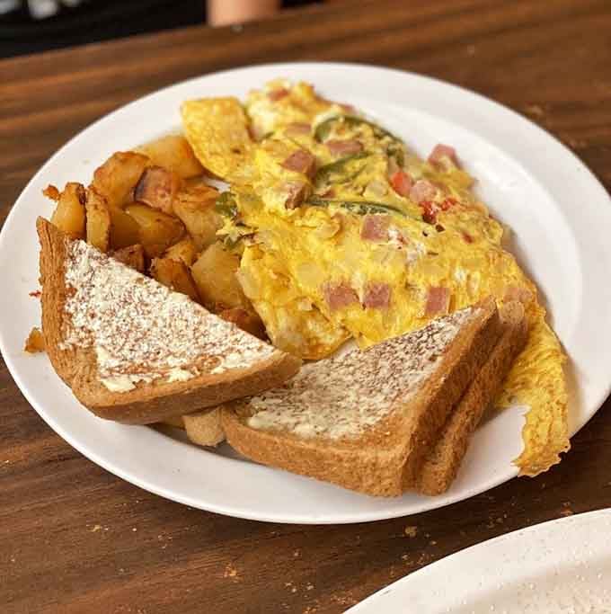 A Western omelet loaded with ham, peppers, and home fries, the kind of plate that makes you feel genuinely accomplished before noon.