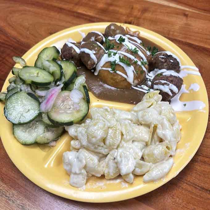 Meatballs, mac and shells, and cucumber salad on one plate. Comfort food wearing its Sunday best.
