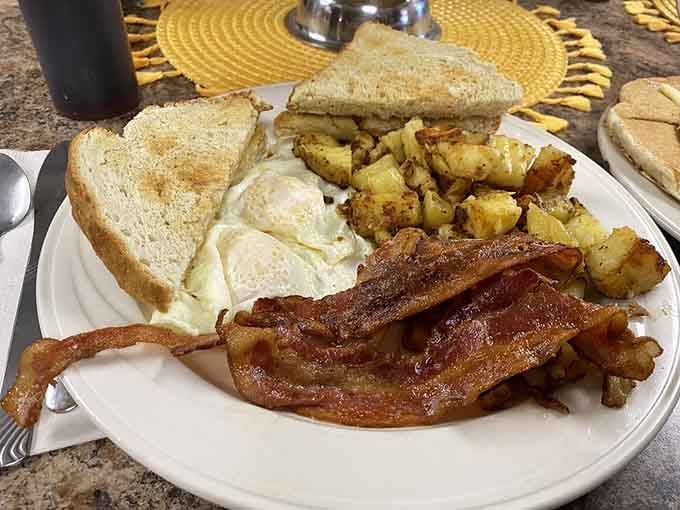 Crispy bacon, golden home fries, eggs cooked just right. This plate means business, the good kind.