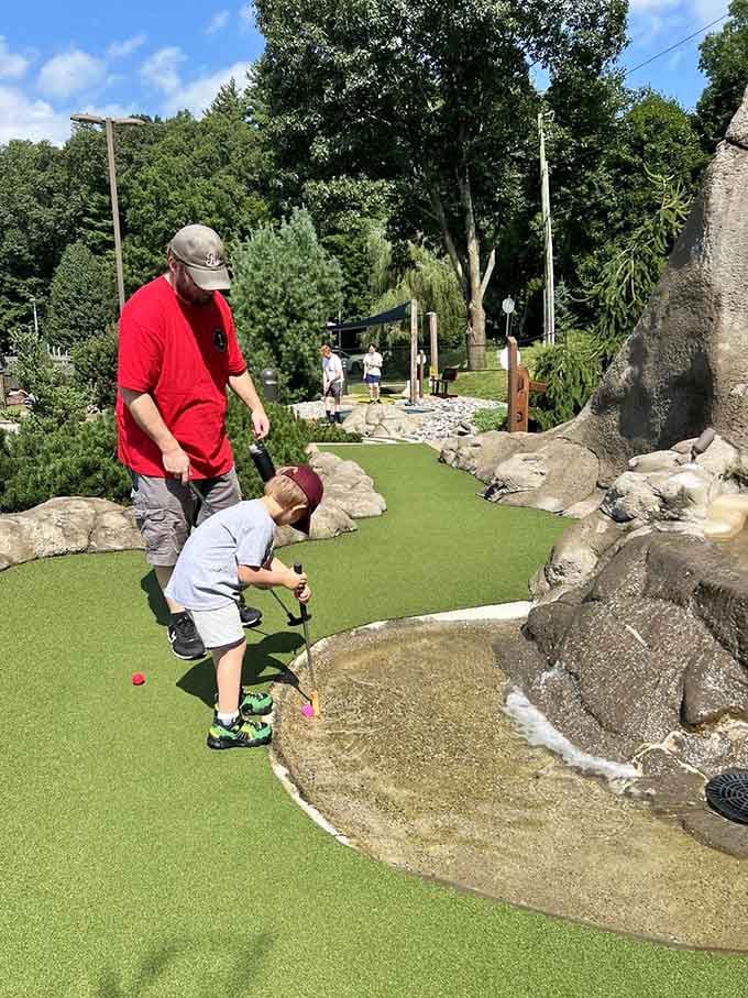 Dad's coaching, the kid's swinging, and somewhere nearby a waterfall is judging them both equally.