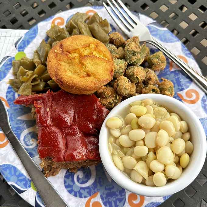 Meatloaf with a glossy red glaze, fried okra, butter beans, and a golden cornbread muffin, this plate means business.