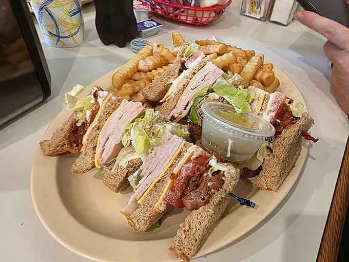 A club sandwich so generously stacked, it practically needs its own zip code and a side of ambition.