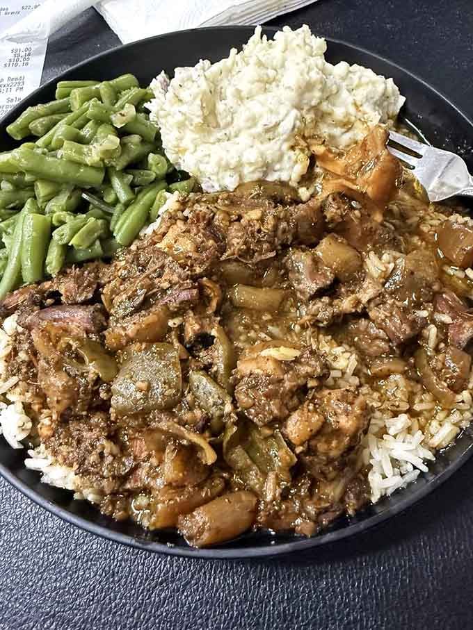 Oxtail stew over rice with string beans and potato salad, a plate that means serious business from the first bite.