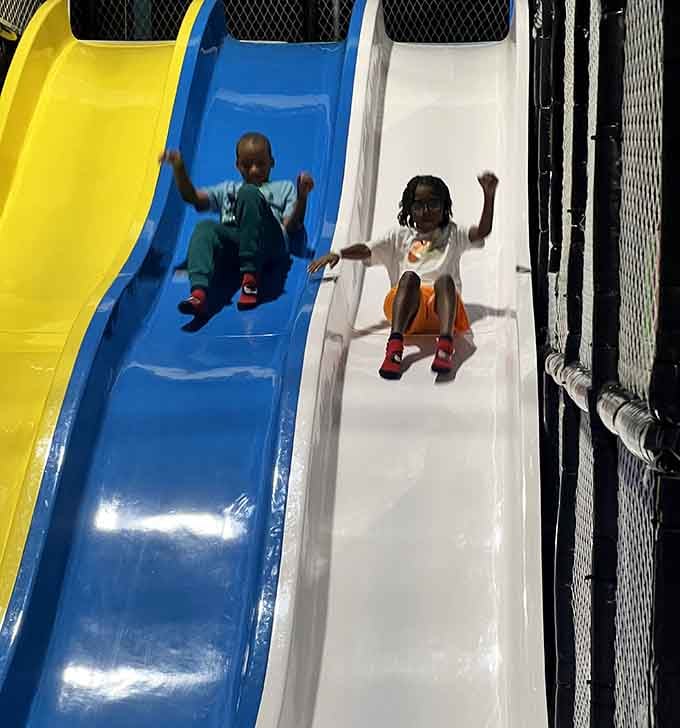 Two kids racing down the slides, arms up, zero hesitation. This is what pure joy looks like in real time.