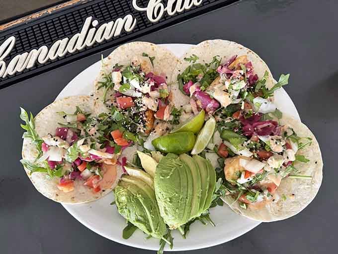 Golden, crispy haddock with a lemon wedge, coleslaw, and baked beans, this plate is a love letter to classic lakeside dining.
Four fish tacos loaded with fresh avocado, pico de gallo, and arugula, proof that Wisconsin harbors have serious culinary range.