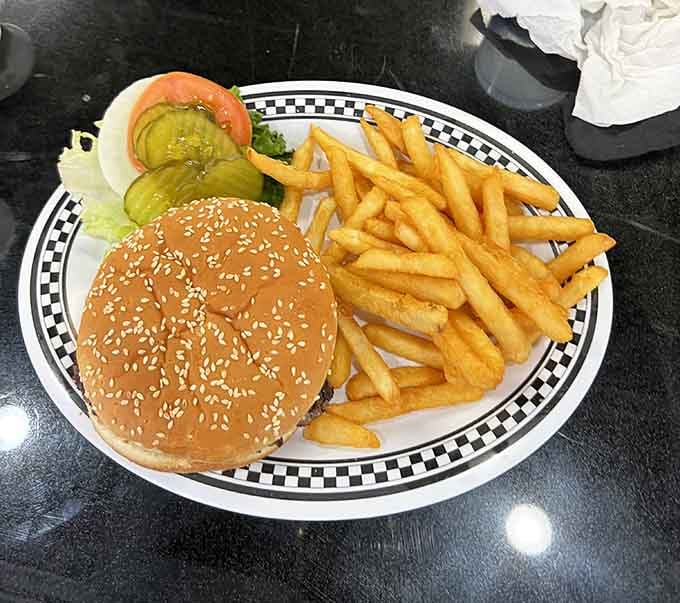 A proper burger with golden fries on a checkered plate. Simple, honest, and completely satisfying.