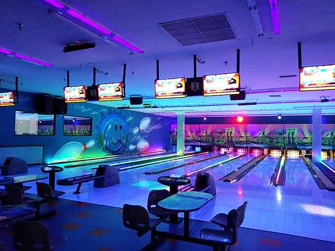 Neon lights, glowing lanes, and a grinning bowling pin mural, this is not your grandfather's bowling alley.