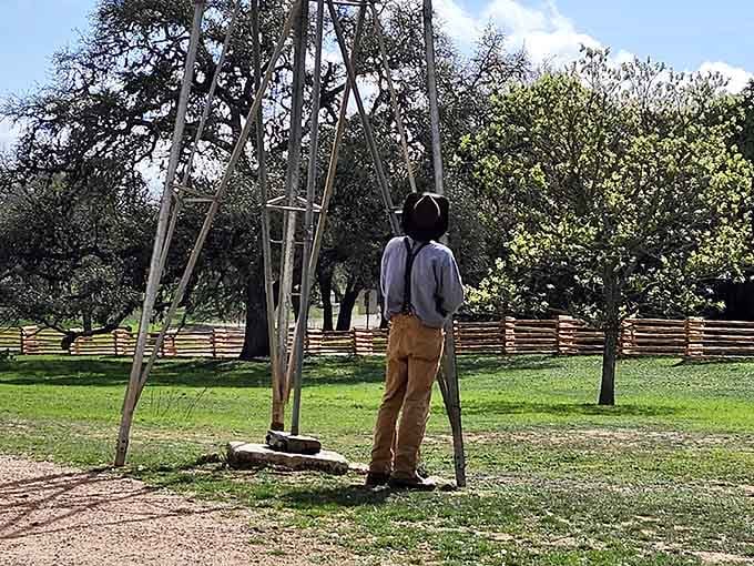 A period-dressed interpreter pauses near the windmill, looking like he genuinely belongs in this century, not yours.