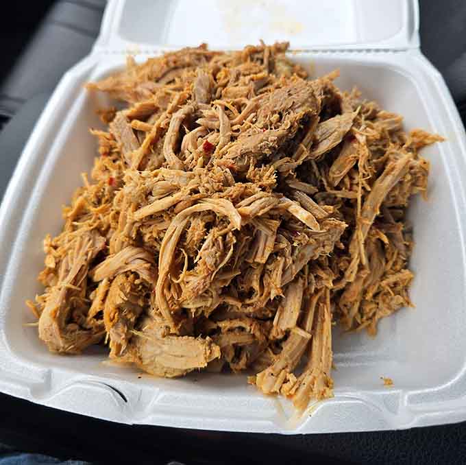Pulled pork so tender and beautifully seasoned, it practically floats into the container like it's proud of itself.