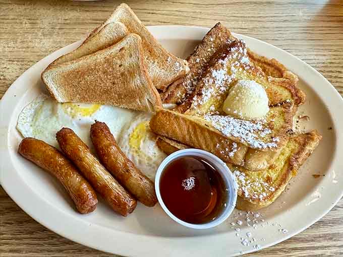 French toast dusted with powdered sugar and paired with sausage links, pure morning perfection on a plate.