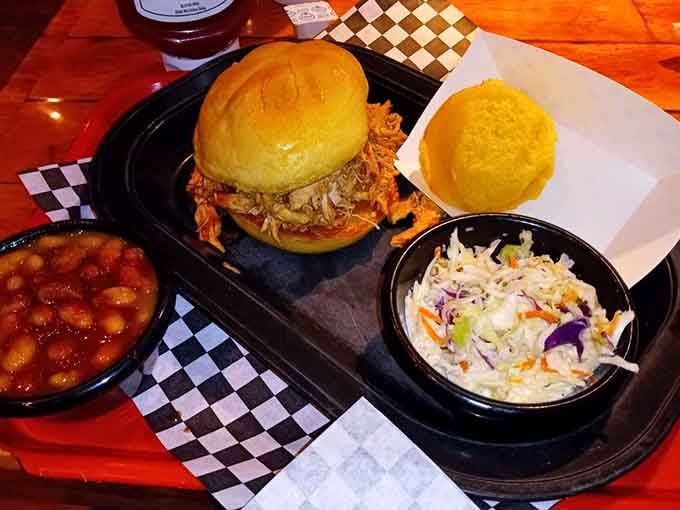 Pulled chicken piled high on a bun, with baked beans and slaw standing proudly alongside.