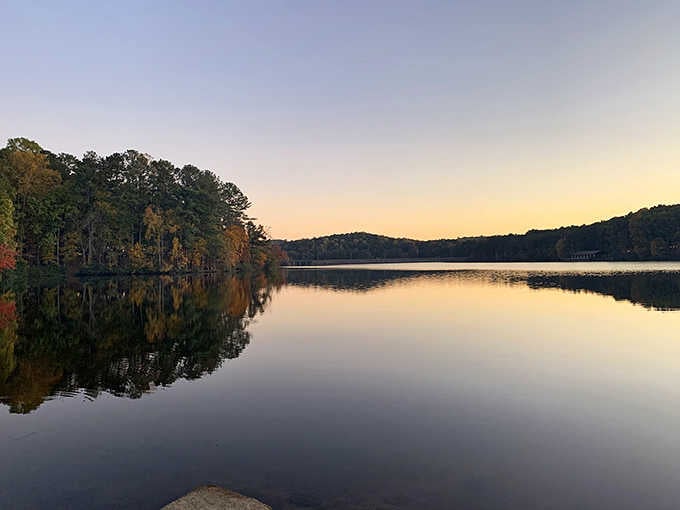 Golden hour at Stone Mountain Lake, where the water reflects sky like nature's own Instagram filter, no app required.