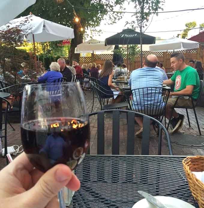 String lights overhead, red wine in hand, and good company all around, this patio scene is pure New England magic.