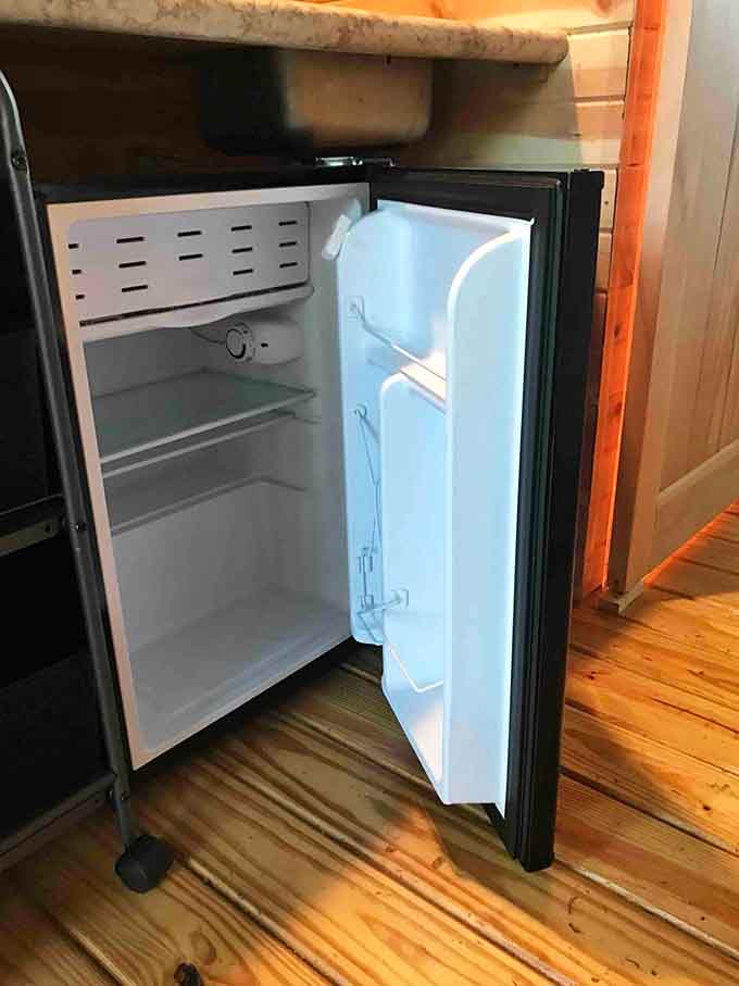That mini fridge is small, but it holds enough to make your forest stay feel civilized.