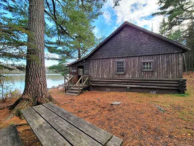 Tucked beside a glassy lake and draped in pine needles, this rustic cabin is the definition of unplugged perfection.