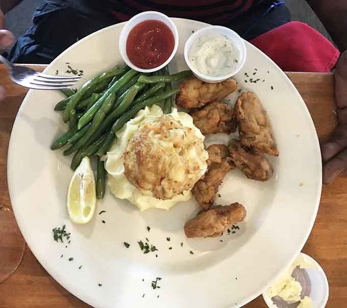Crab cake and fried oysters sharing one plate. Somebody in that kitchen really understands the assignment.