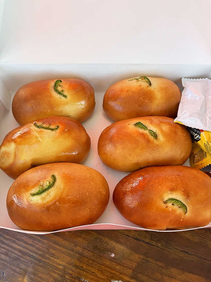 Six golden, jalape&ntilde;o-topped kolaches sitting in a box, looking like the best decision you've made all week.