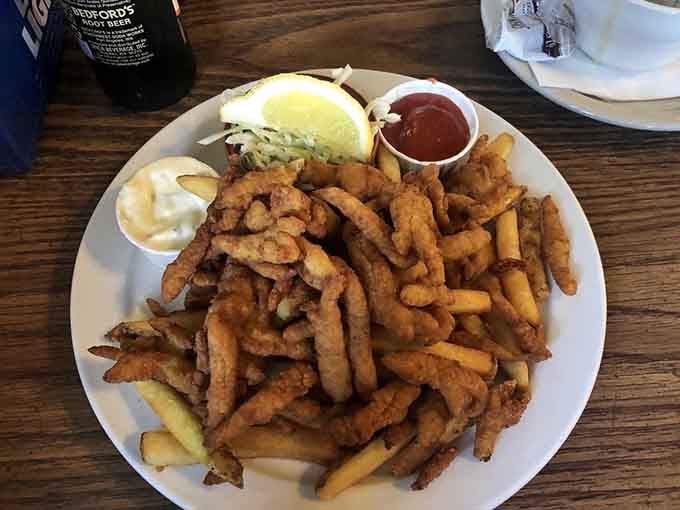 Golden fried clam strips piled high with fries, coleslaw, and tartar sauce prove that simple done right wins every time.
