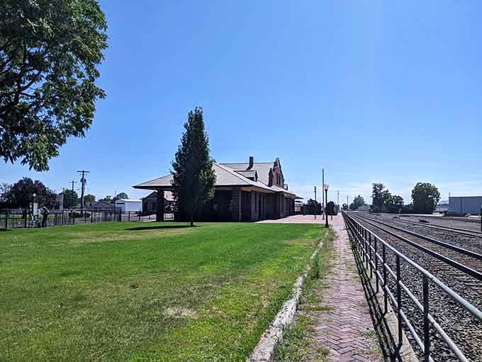 The old railroad park sits peacefully beside the tracks, a living postcard from the town's hardworking origins.