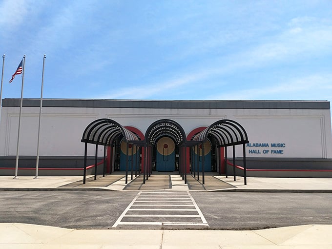 The bold arched canopy and teal doors announce this place like a opening chord you feel in your chest.