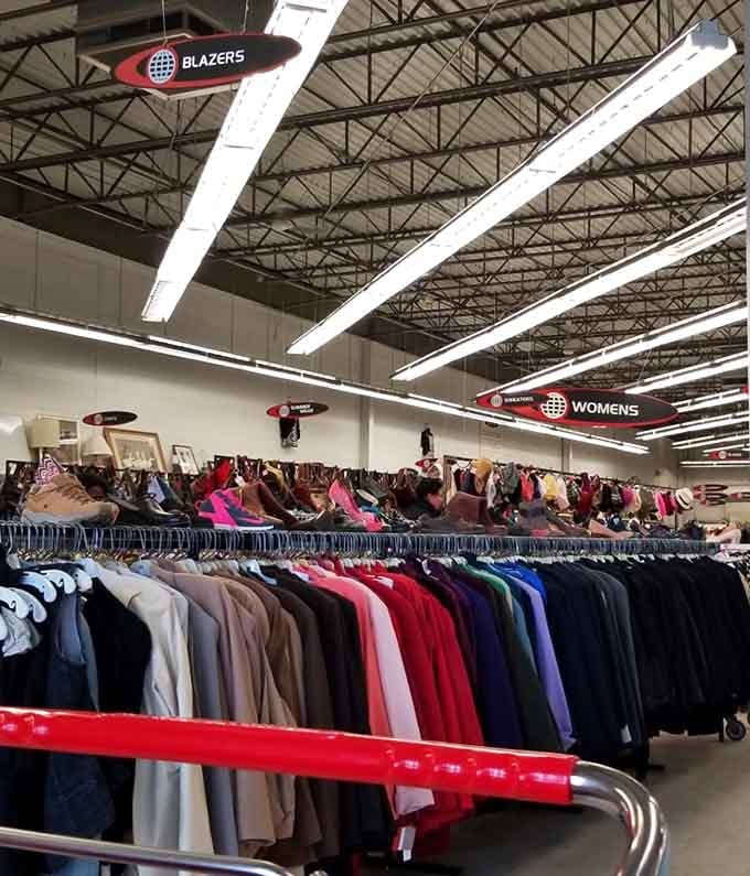 Blazers, sweaters, and women's wear stretch as far as the eye can see under bright warehouse lighting.