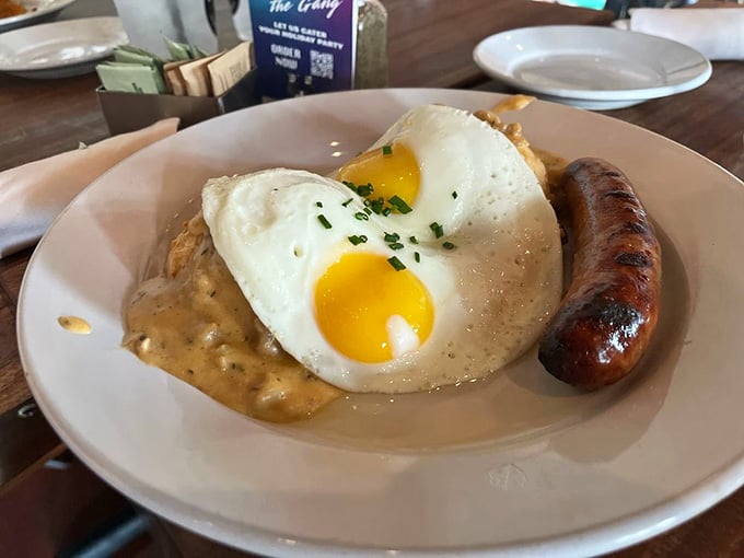 Biscuits and gravy crowned with sunny-side eggs and a grilled sausage link. Southern comfort never looked this good.