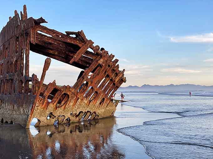 Tiny figures beside the towering wreck remind you just how enormous this old ship really was.